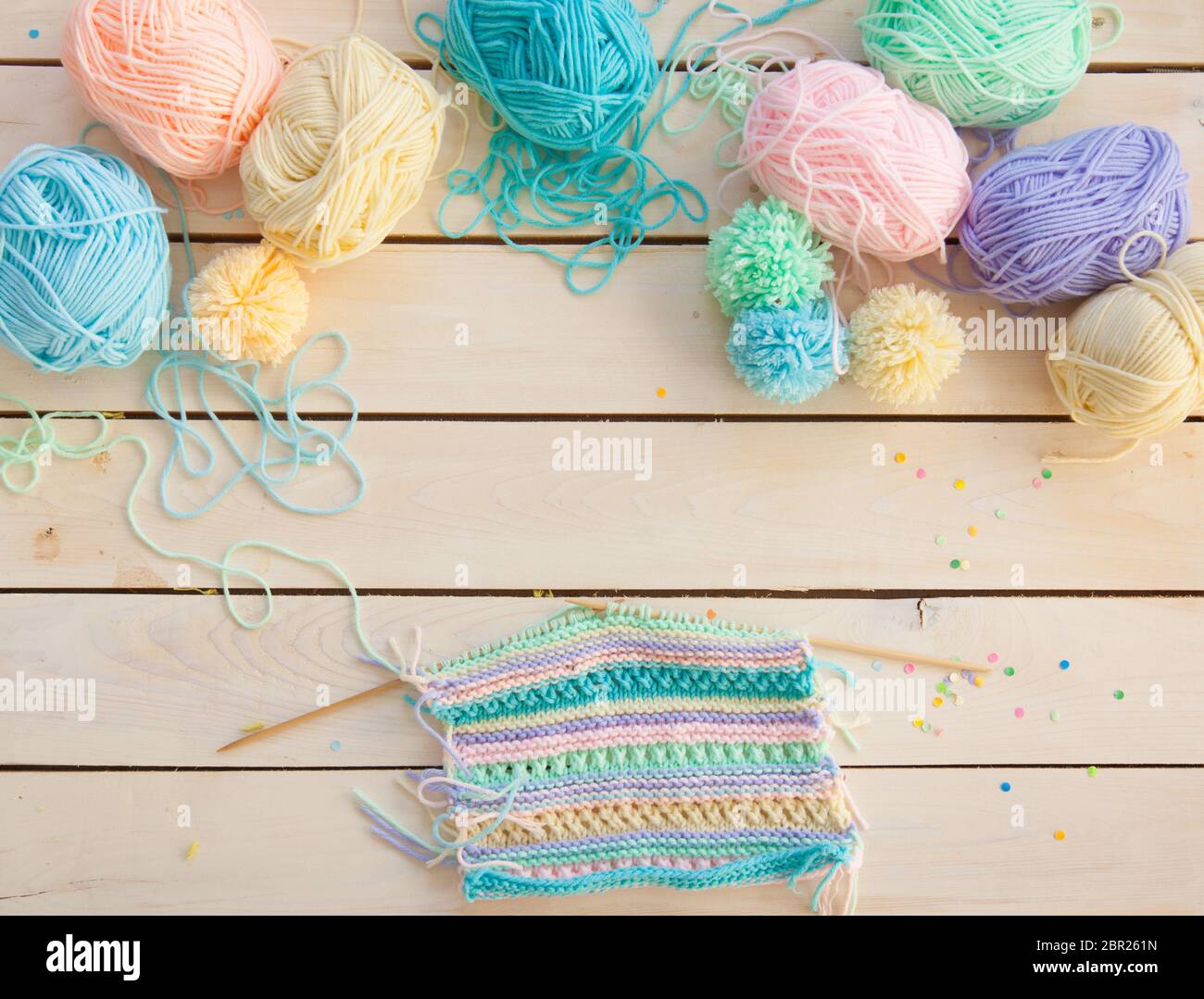 Balls of pastel colored yarn. View from above. Sample knit. Women's ...