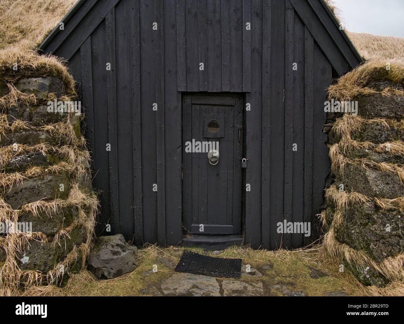 The wooden facade with a door of a peat house in Iceland near Hella ...