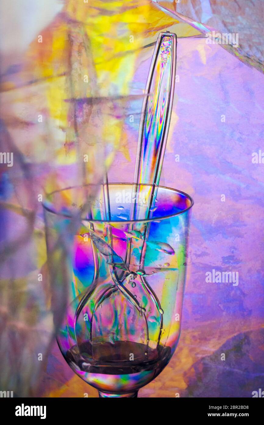Abstract with glass and cutlery showing light refraction and rainbow ...