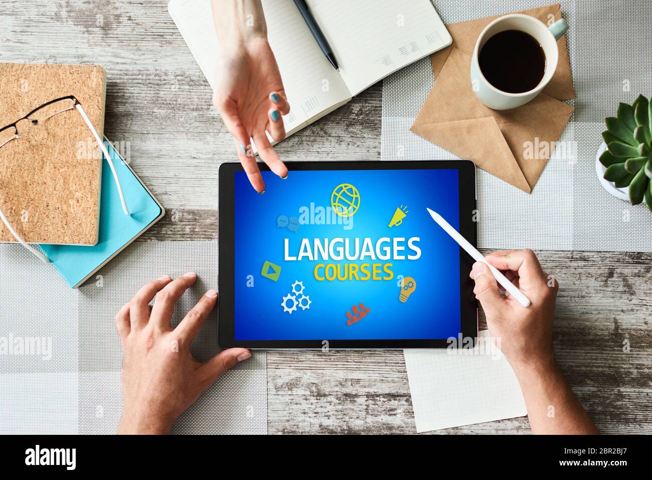 Tablet with languages courses text and icons on screen. English ...