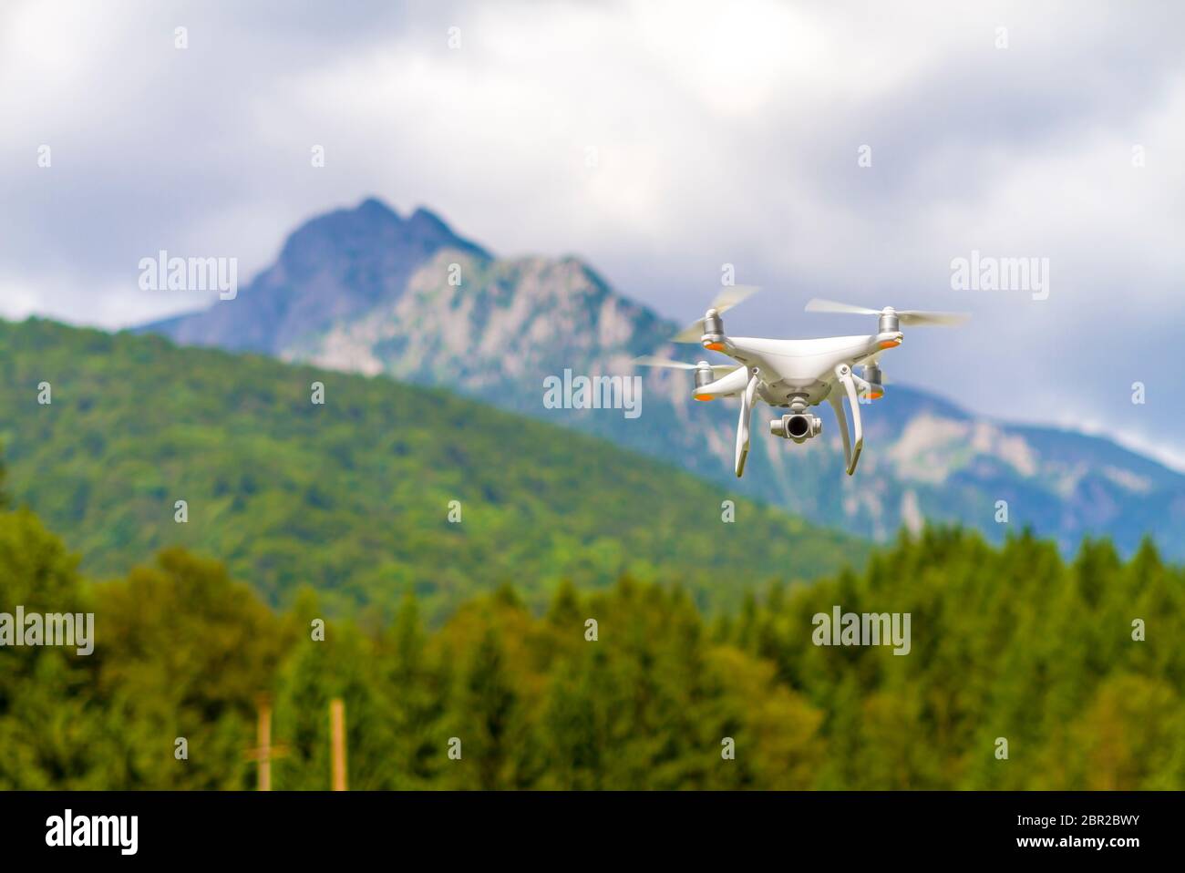 White drone quad copter with high resolution digital camera flying in ...