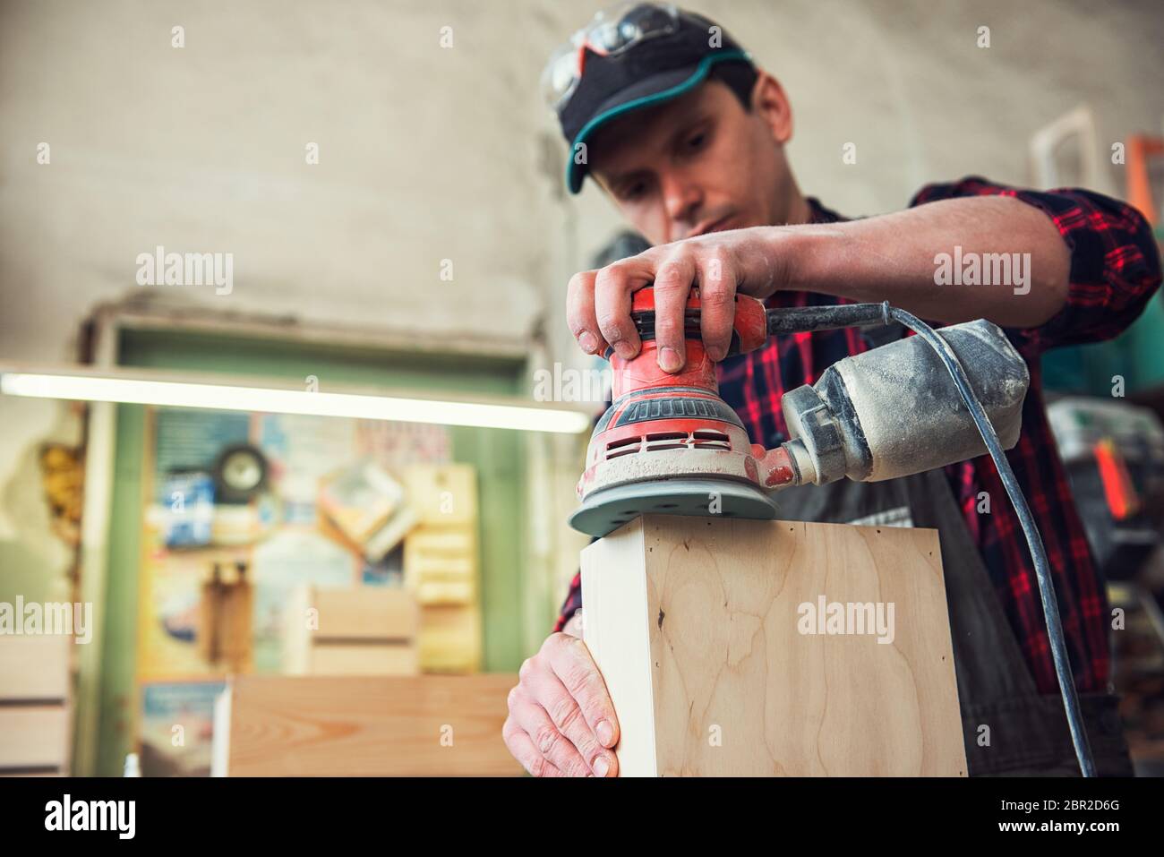 Worker grinds the wood box of angular grinding machine Stock Photo - Alamy