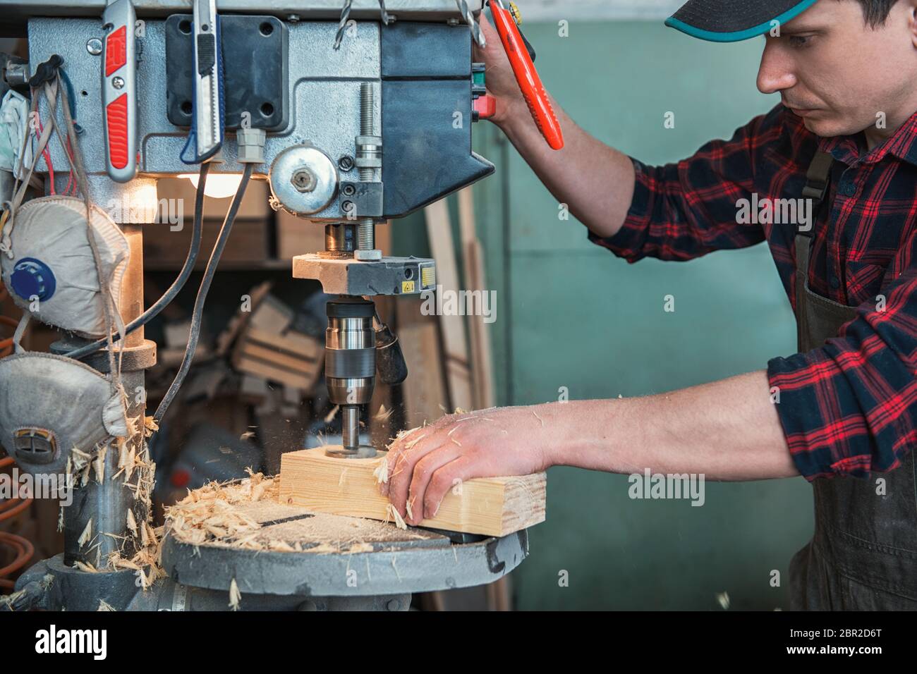 Carpenters with electric drill machine drilling wooden board at ...