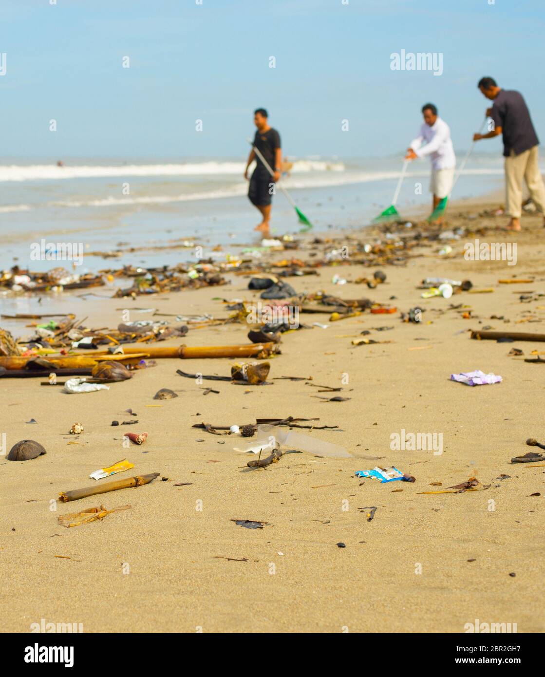 Group of people cleaning up beach from the garbage and plastic waste ...