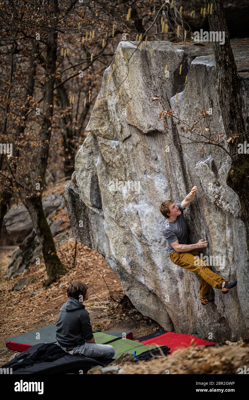 Rock climbers climbing on a boulder rock outdoors Stock Photo - Alamy
