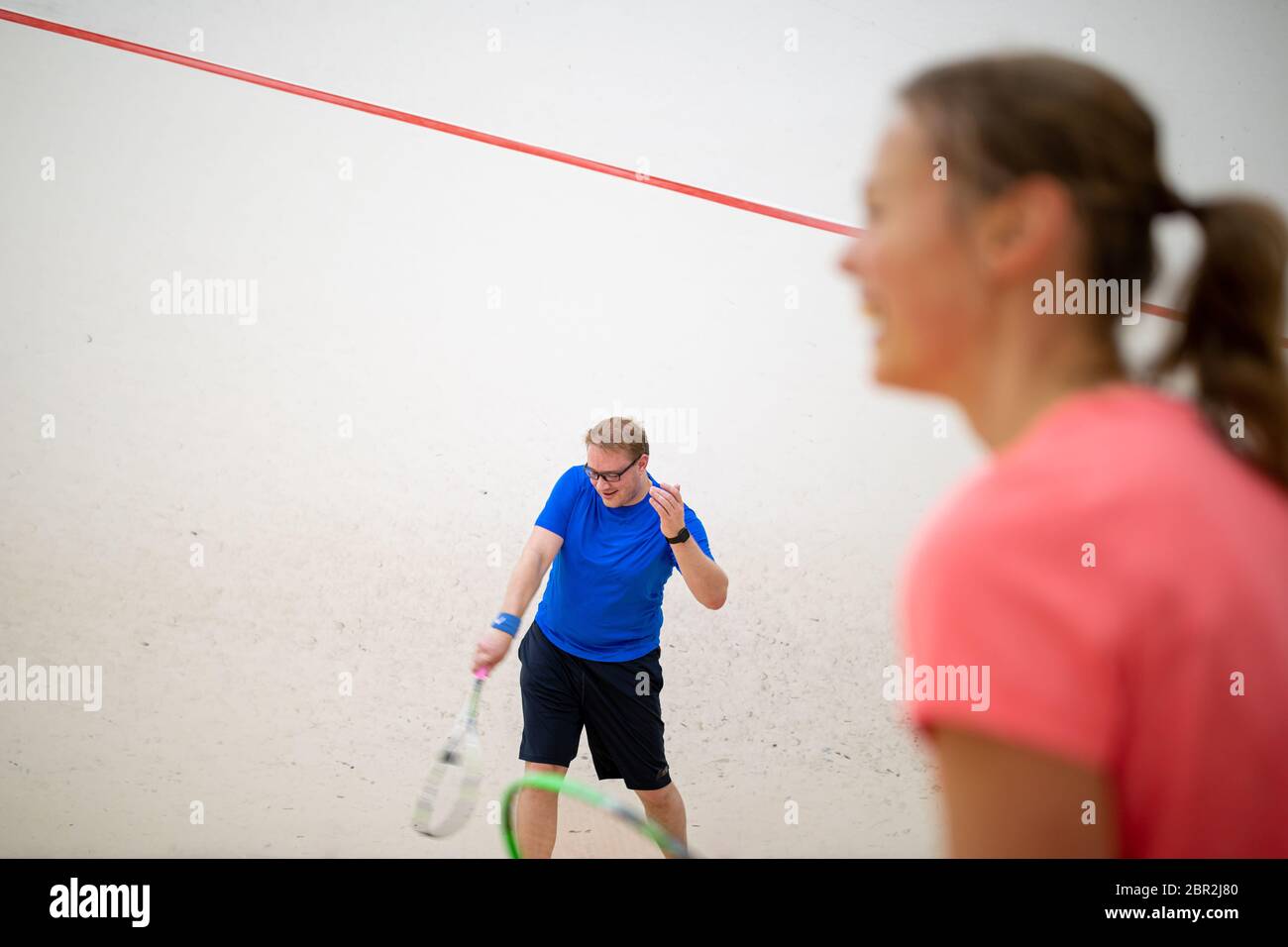 Squash players in action on a squash court (motion blurred image; color ...