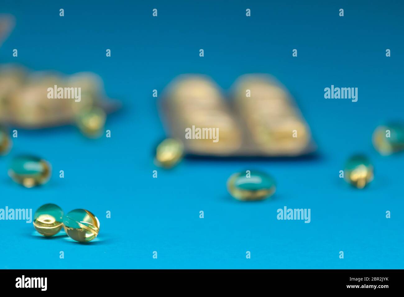 fish oil capsules in blisters on blue background Stock Photo - Alamy