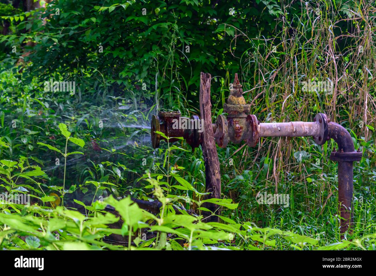 Old iron Metallic water pipe leaking. Rusty burst pipe spraying water ...