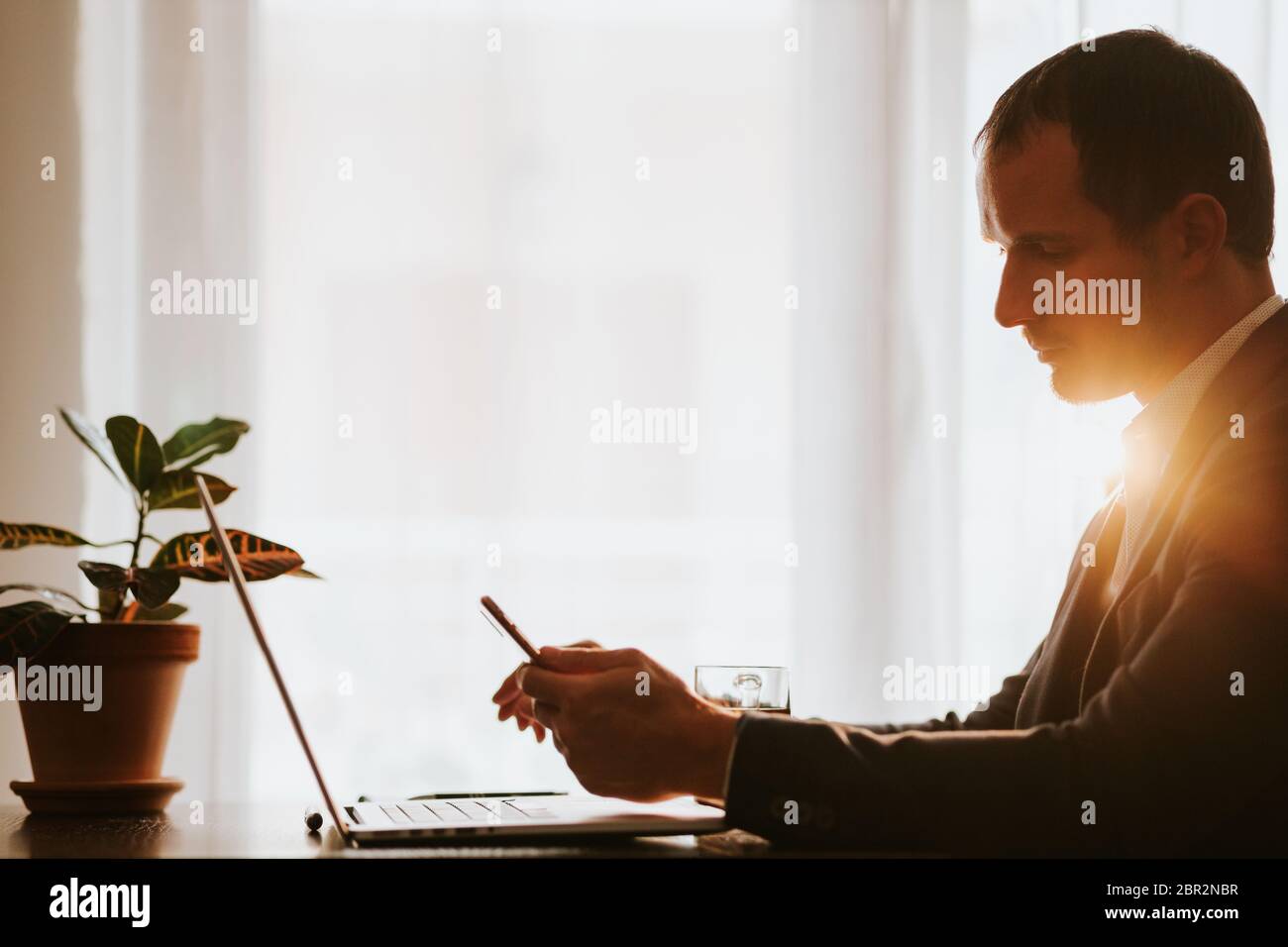 office worker using phone and laptop working day indoors. businessman ...