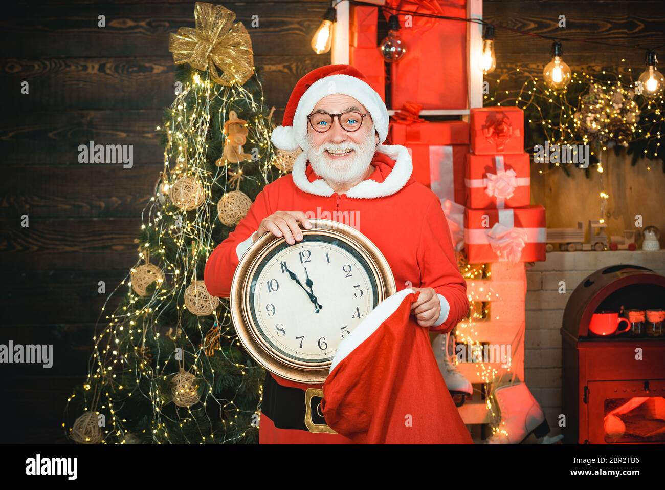 Santa make funny face and holding clock showing five minutes to ...