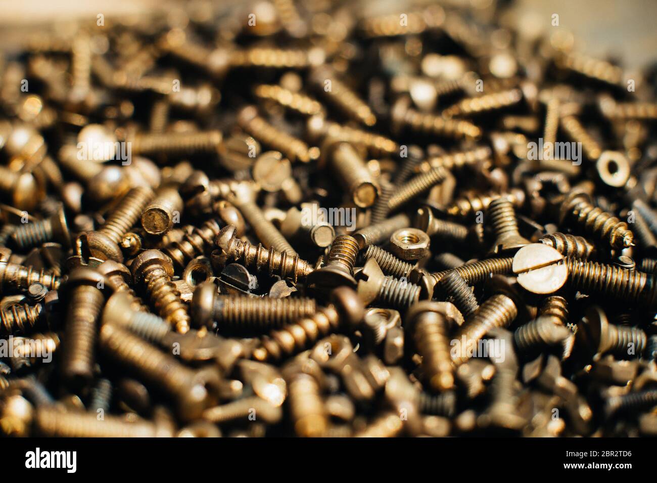 Close-up, macro. Old Soviet brass screws and nuts with countersunk head ...