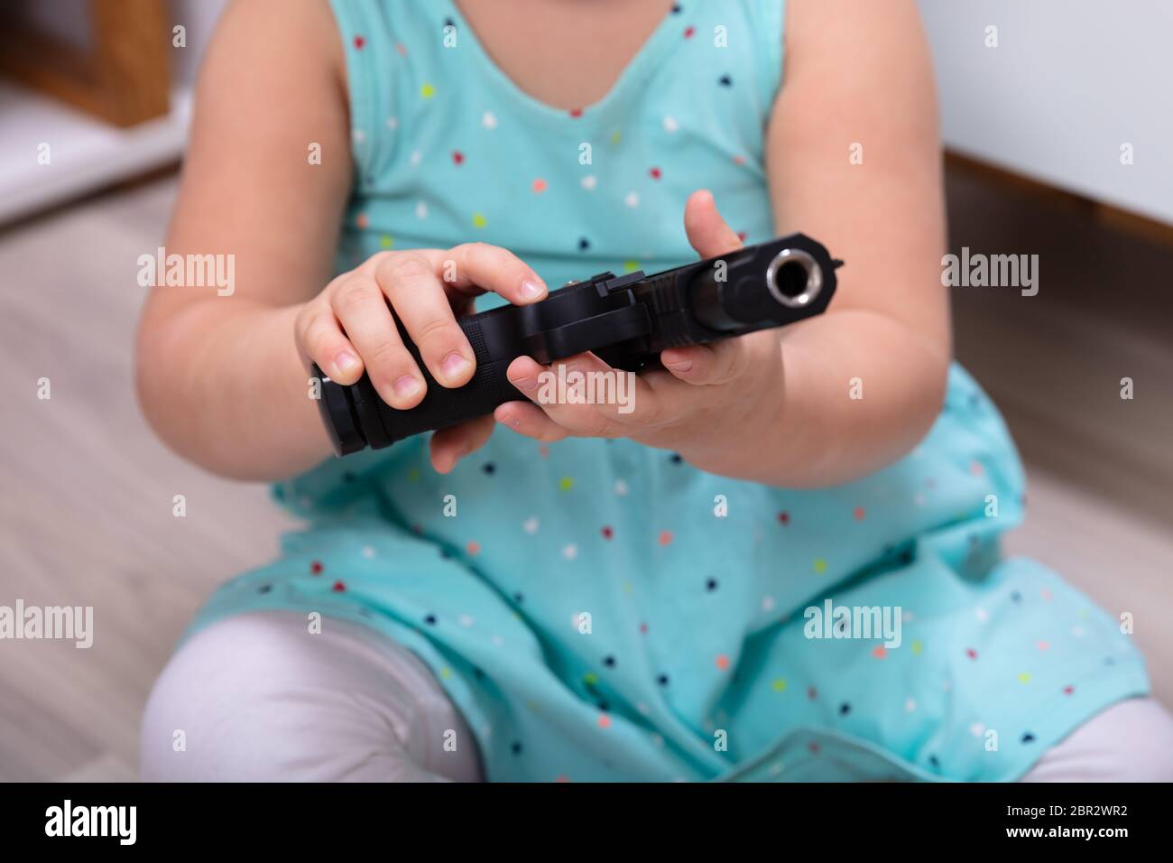 Close-up Of Little Girl's Hand Holding Gun At Home Stock Photo - Alamy