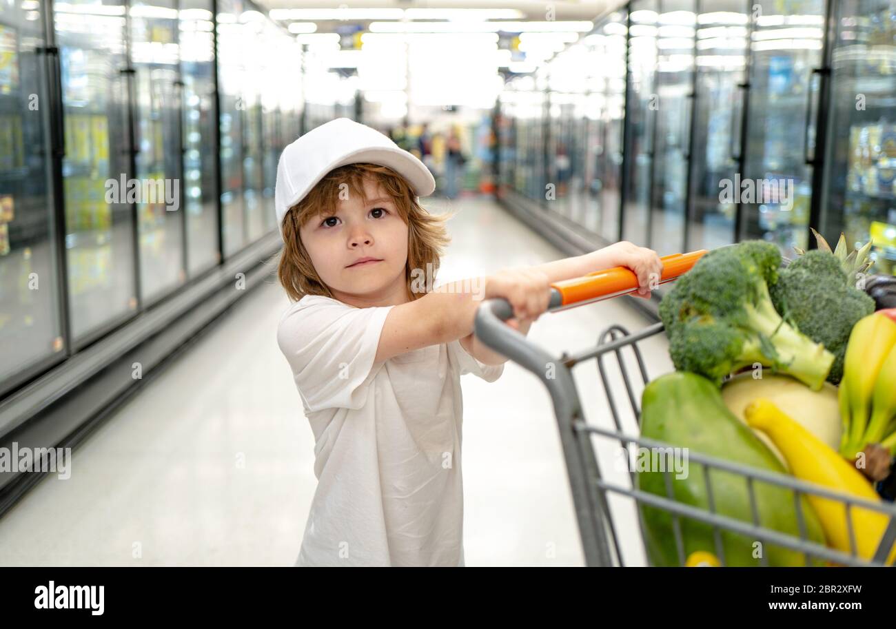 Cute toddler boy in a food store or a supermarket choosing fresh ...