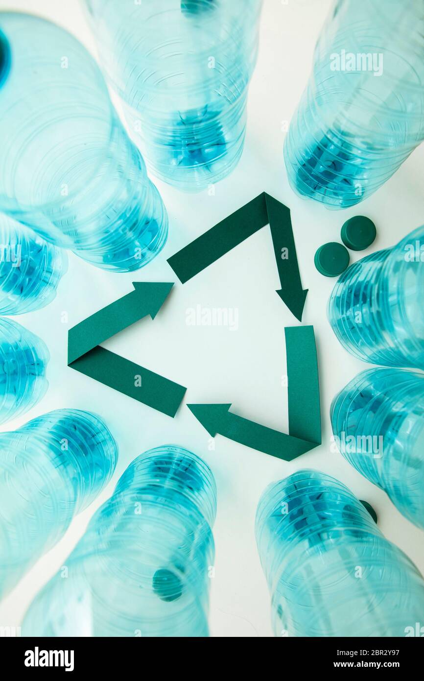 Green paper recycling symbol with empty plastic water bottles Stock ...