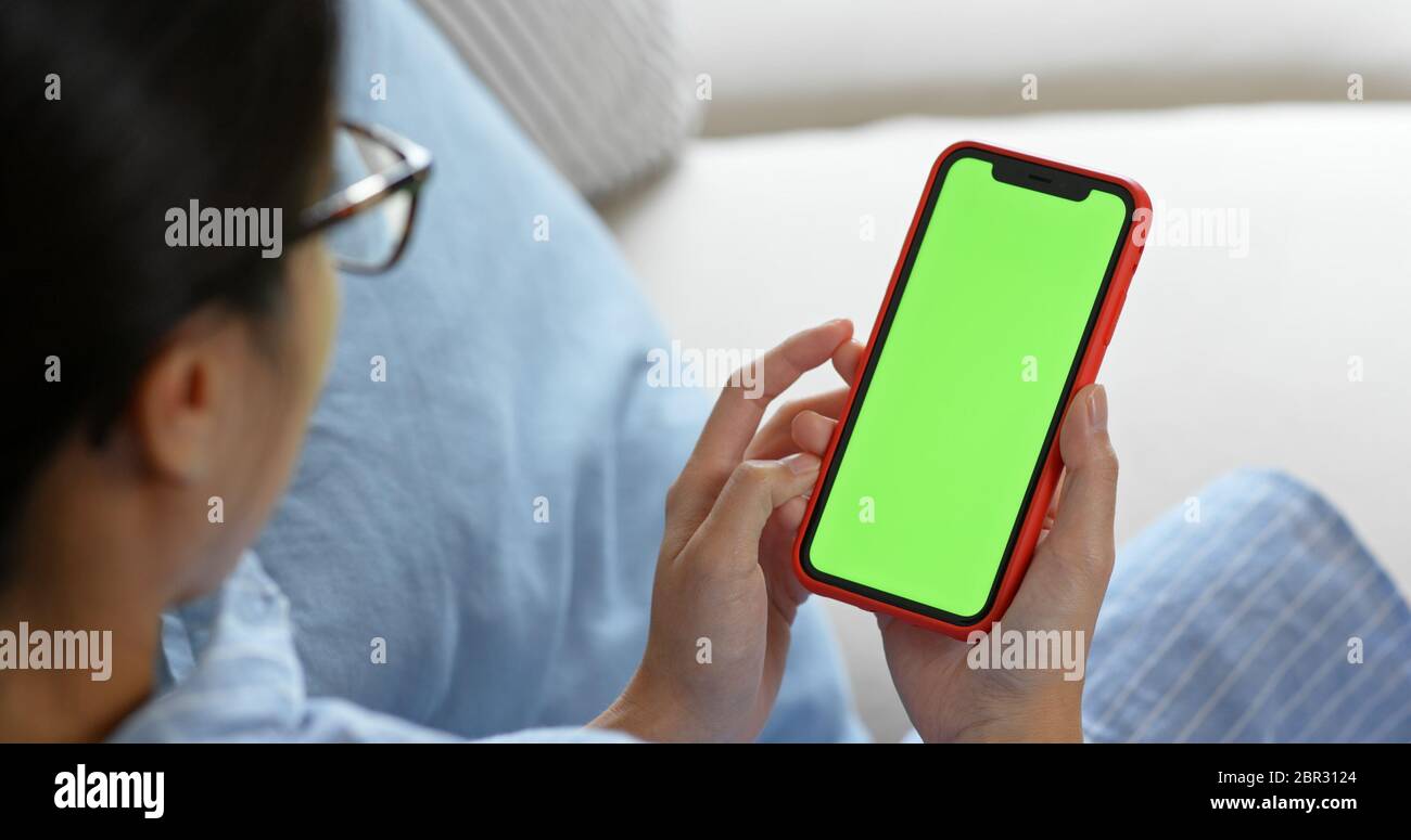 Woman use of mobile phone in green screen at home Stock Photo - Alamy