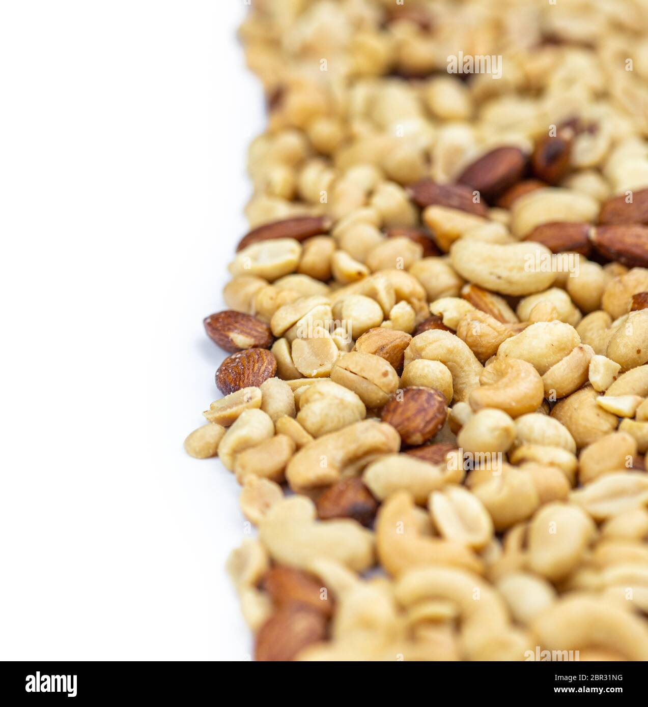Portion of roasted nuts isolated on white background as close up shot ...