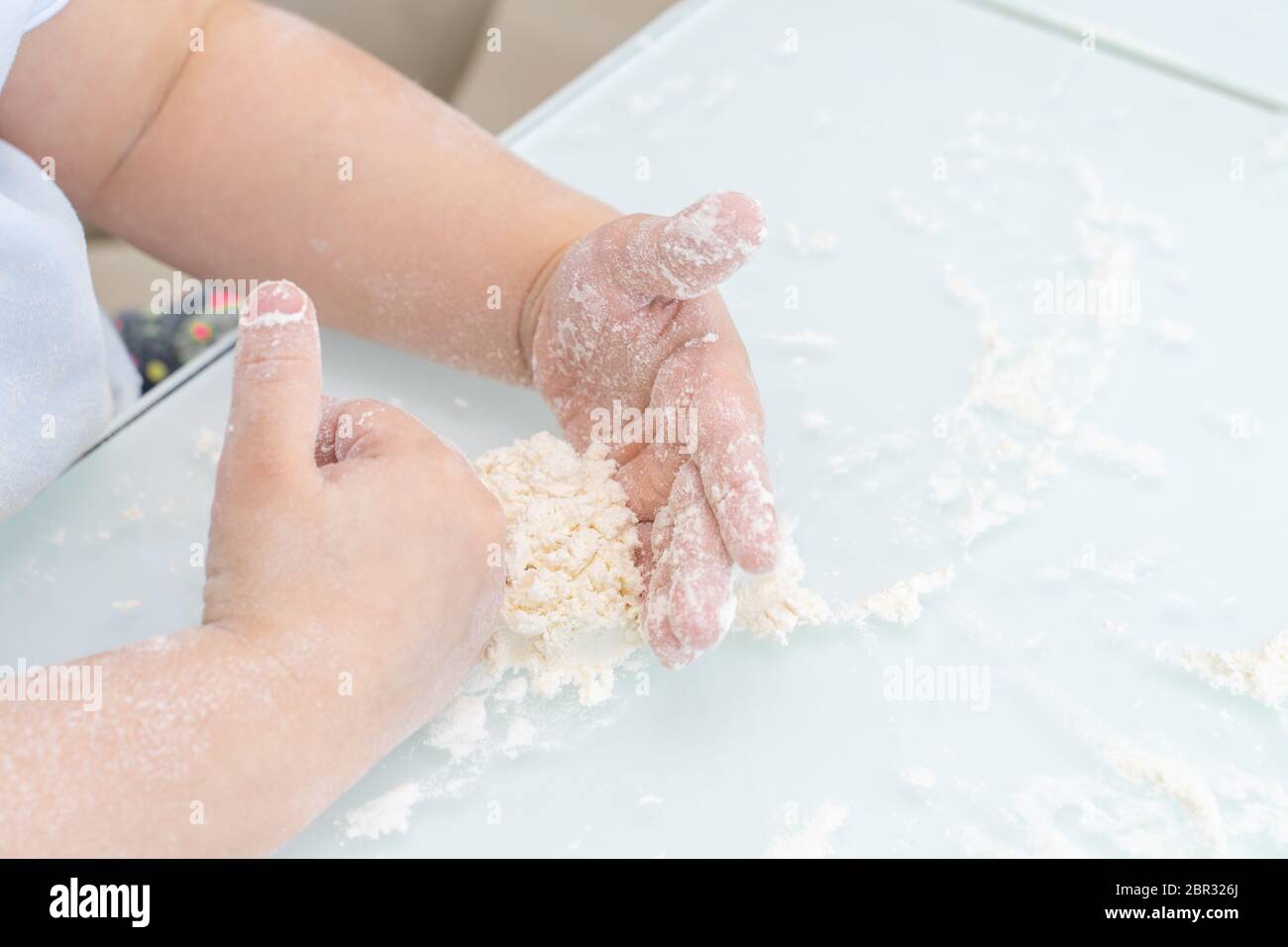 child plays with flour on the table. hand drawing flour Stock Photo - Alamy