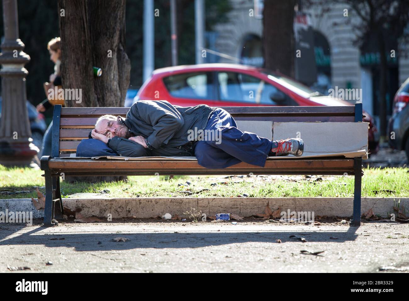 Rome, Italy. January 10, 2016: Homeless man sleeping on the bench. A ...