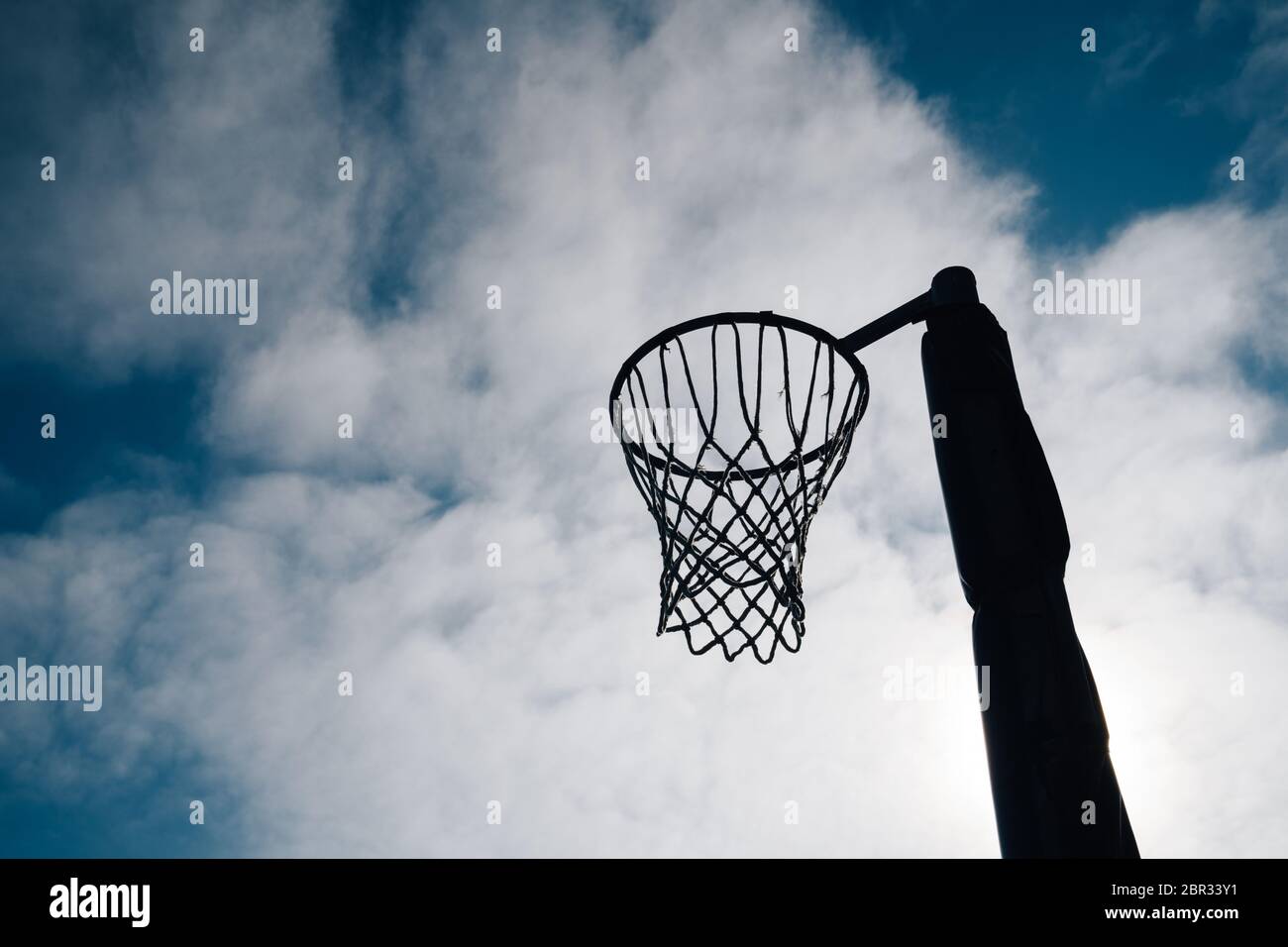 Netball goal ring and net against a blue sky and clouds at Hagley park ...