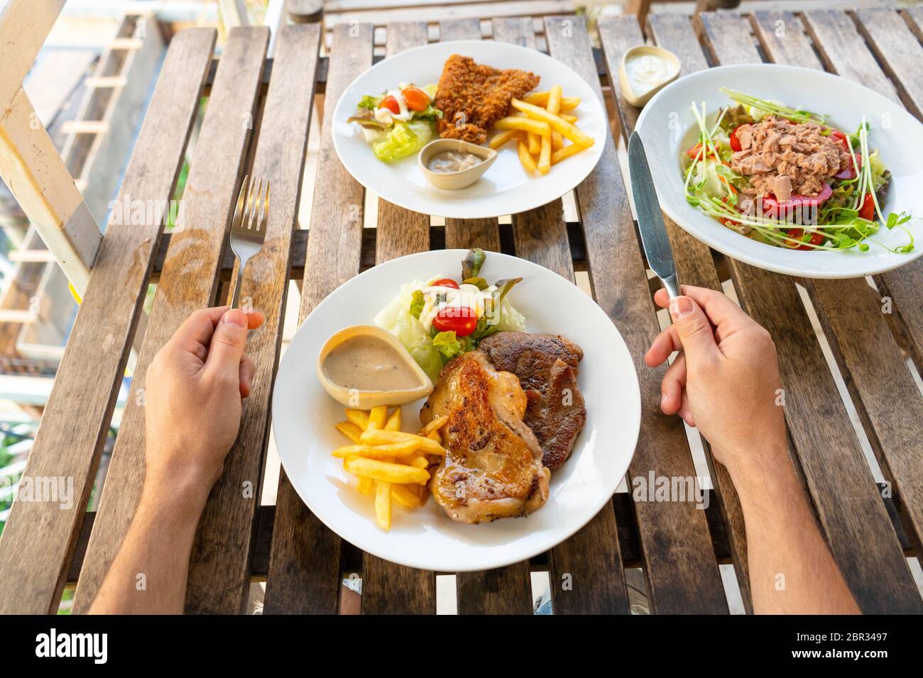 First-person view of a guy eating food in a summer cafe Stock Photo - Alamy