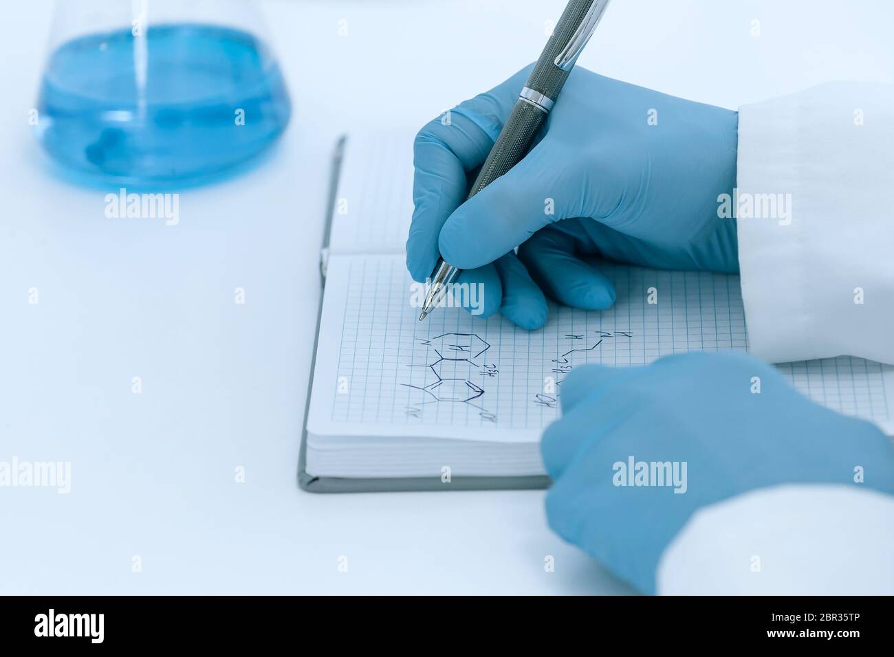 close up. scientist virologist recording test results in a journal ...