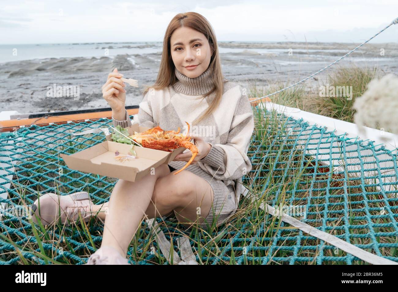 Beautiful asian woman holding a lobster claw or crayfish outdoor with ...