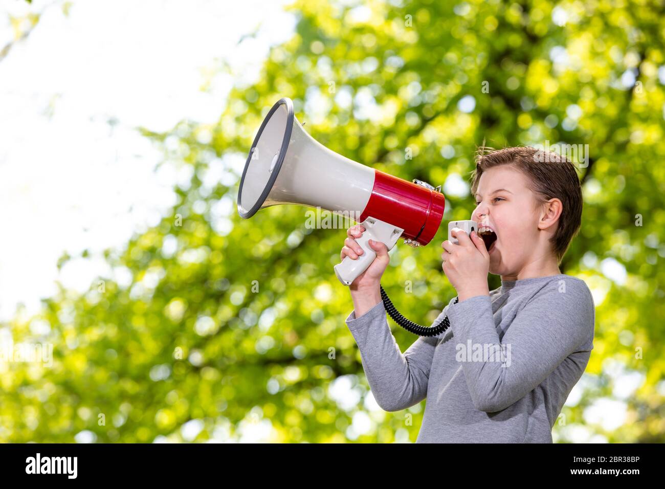 Announcing concept, boy shouting or screaming through the megaphone ...