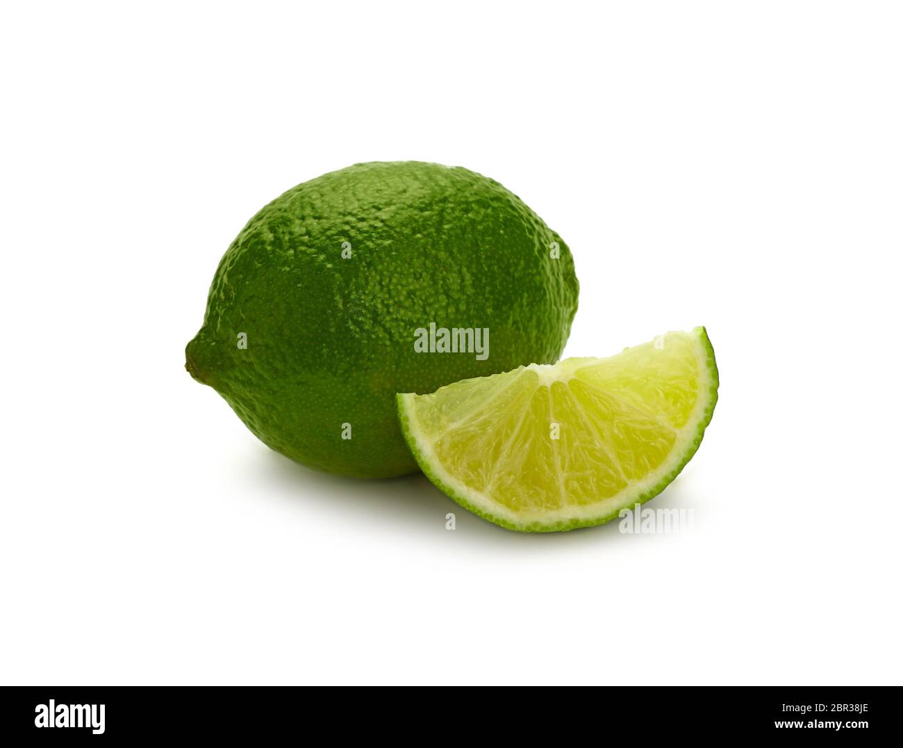 Close up one whole fresh green lime fruit and cut slice wedge, isolated ...