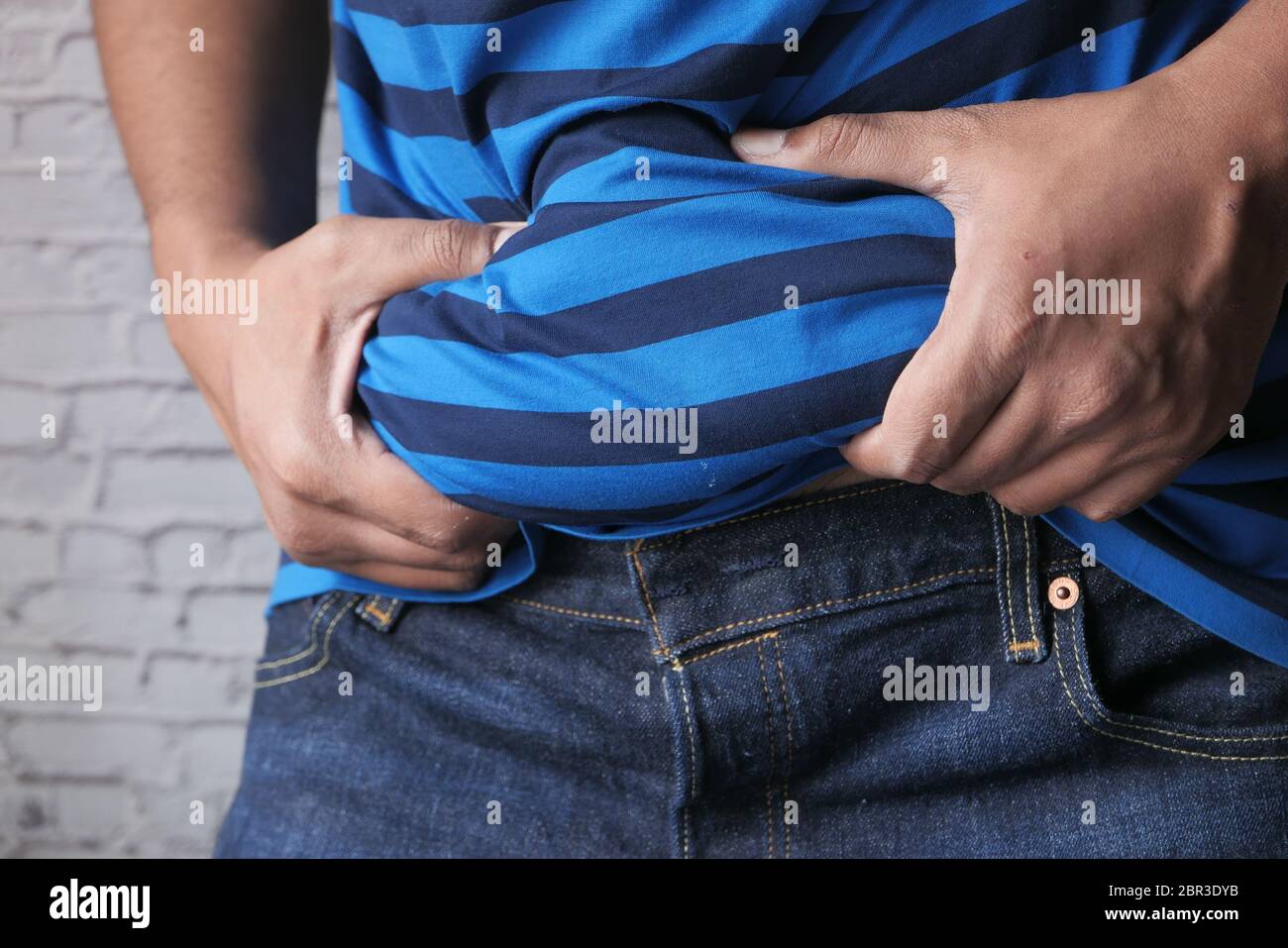 man's hand holding excessive belly fat, overweight concept Stock Photo ...