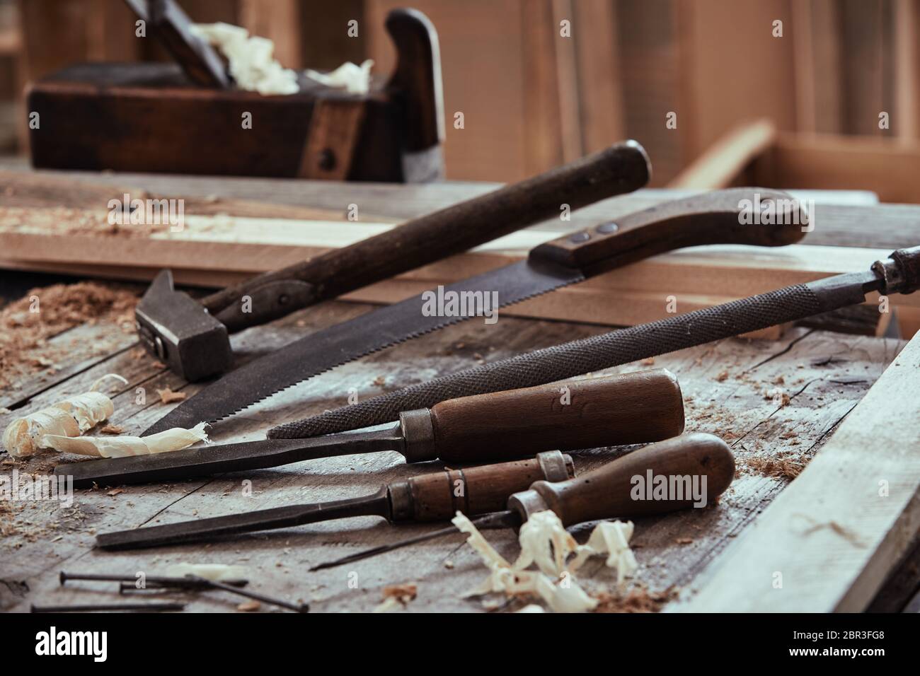 Selection of old vintage tools on a woodworking workbench with chisels ...