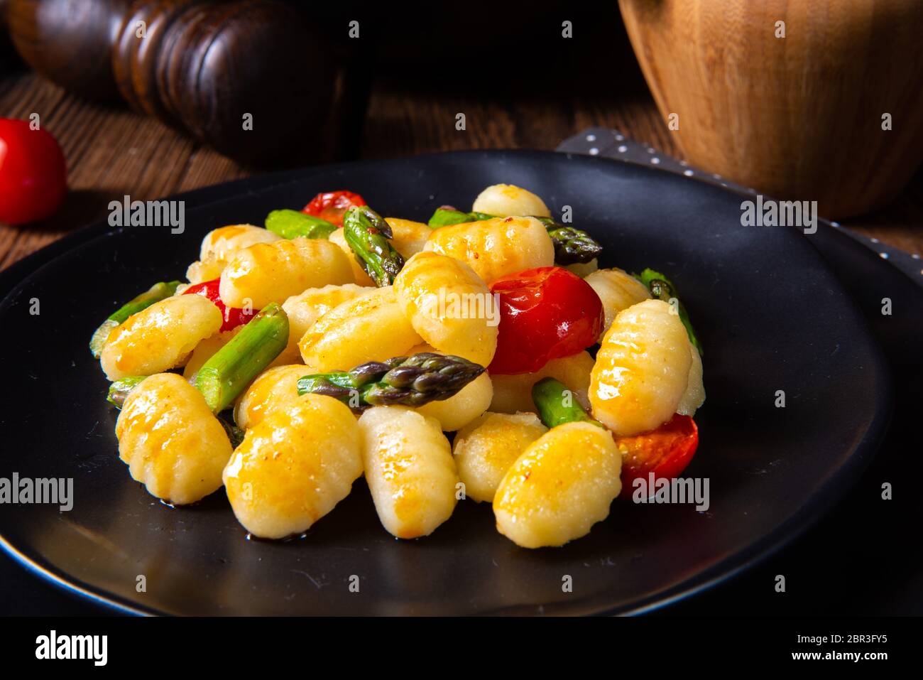 crispy gnocchi with roasted asparagus and tomatoes Stock Photo - Alamy