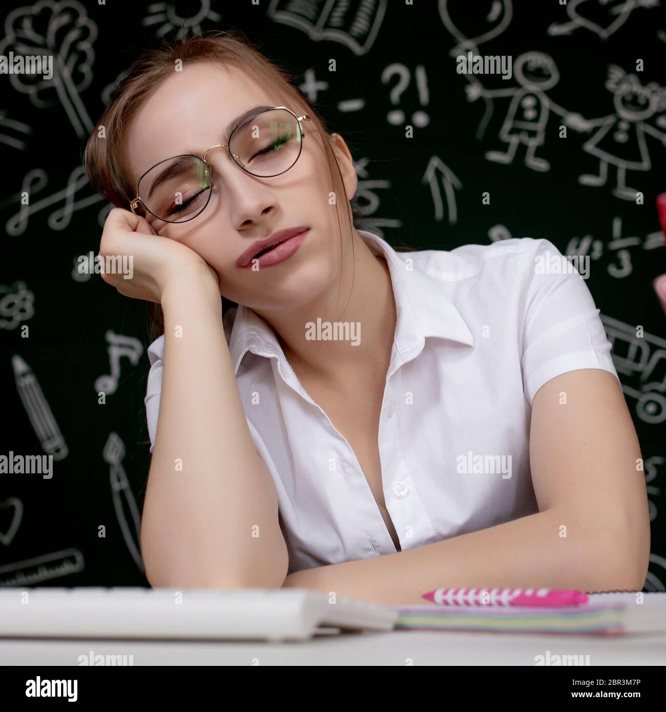 Young female student sleeping in a classroom Stock Photo - Alamy