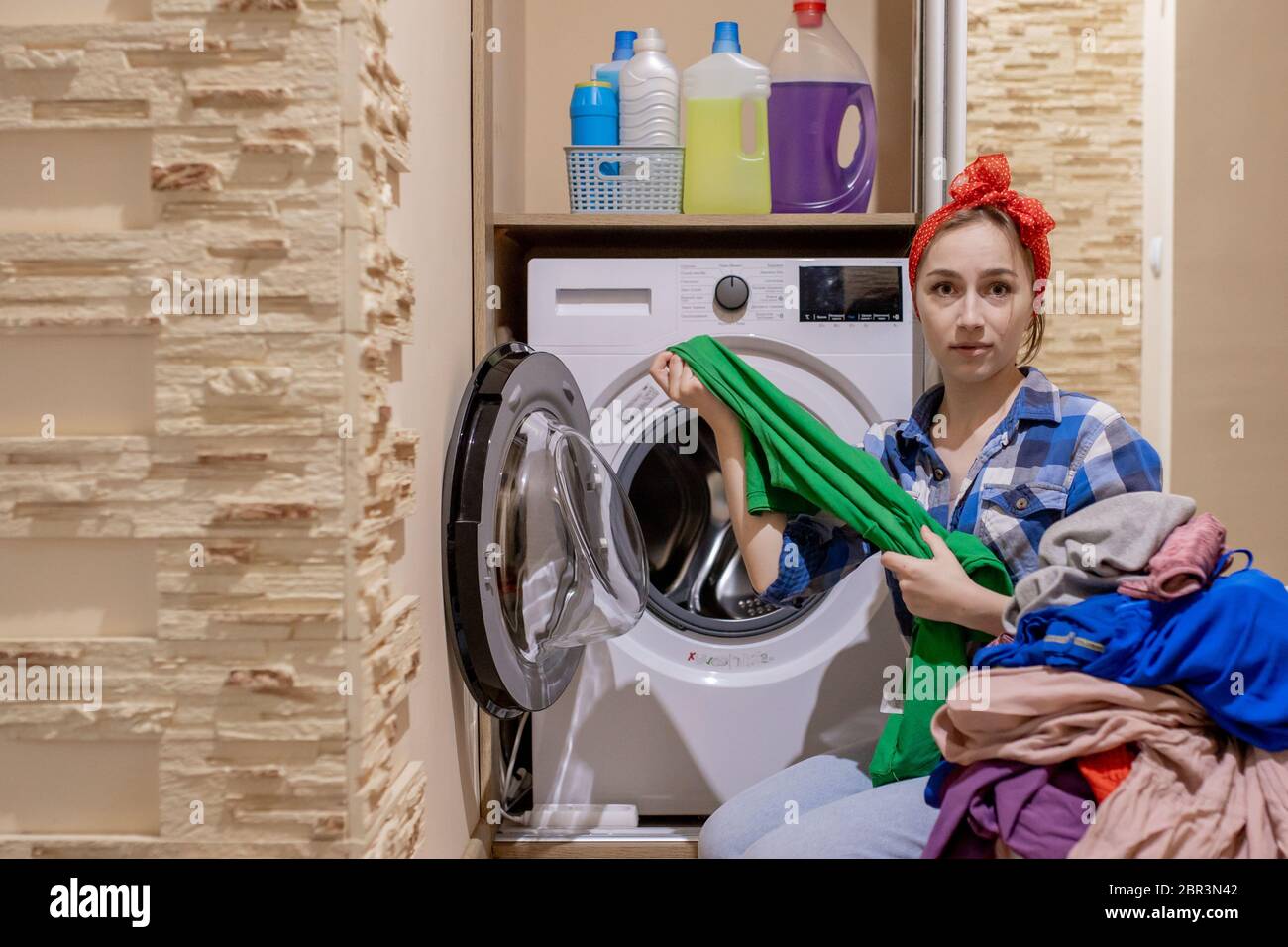 Beautiful young woman doing laundry. Housework Stock Photo - Alamy