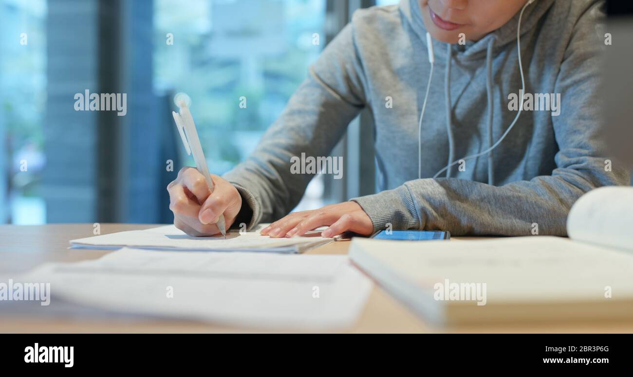 Woman write on the paper note with cellphone at library Stock Photo - Alamy