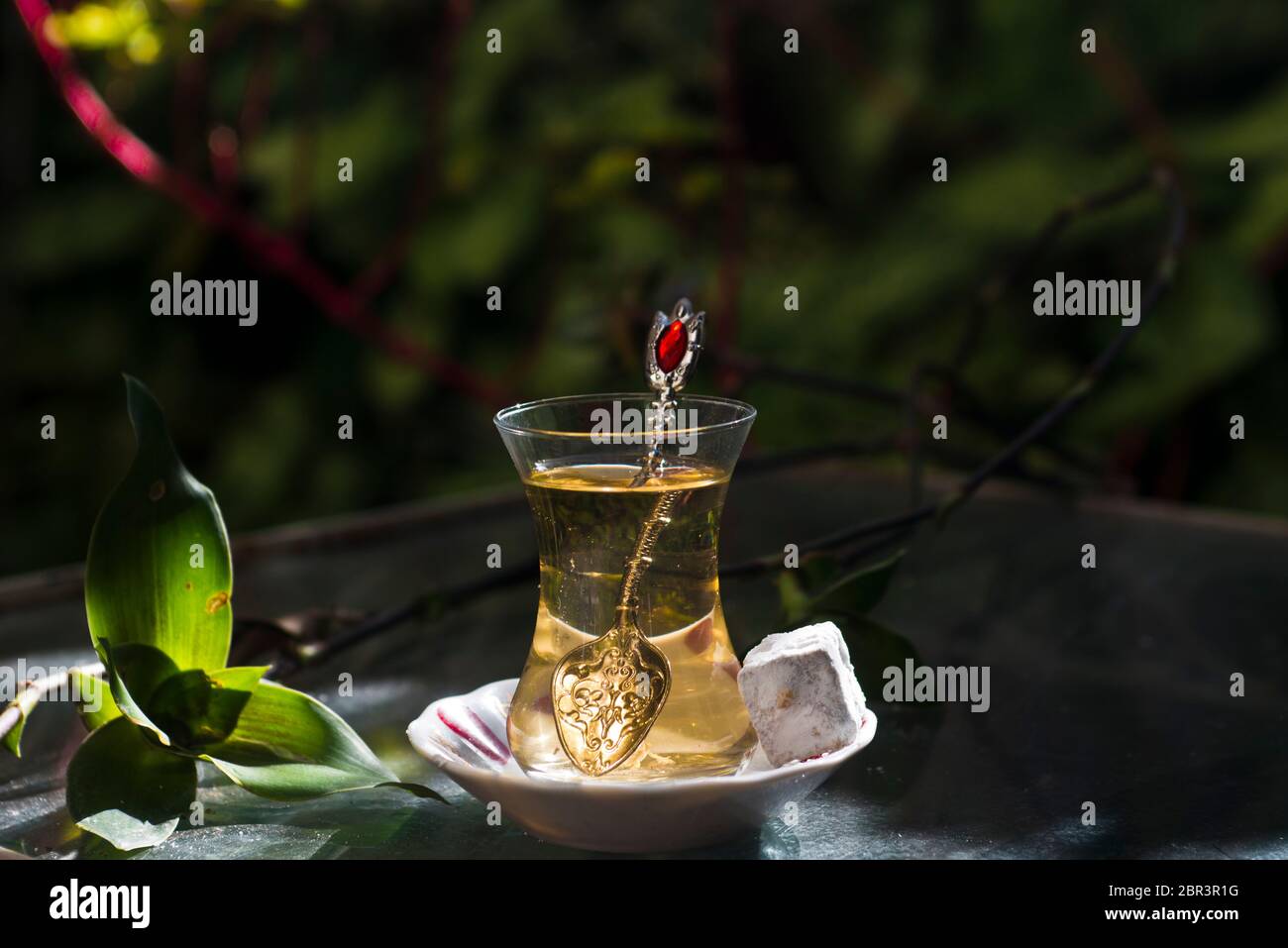 Turkish apple tea and sweet (turkish delights), served on a glass table ...