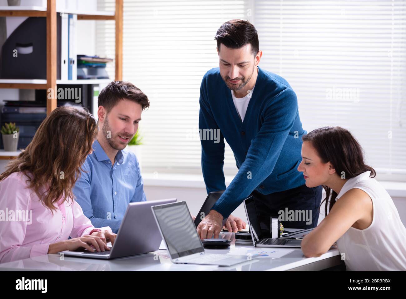 Group Of Businesspeople Working On Laptop During Meeting In Office Stock Photo - Alamy