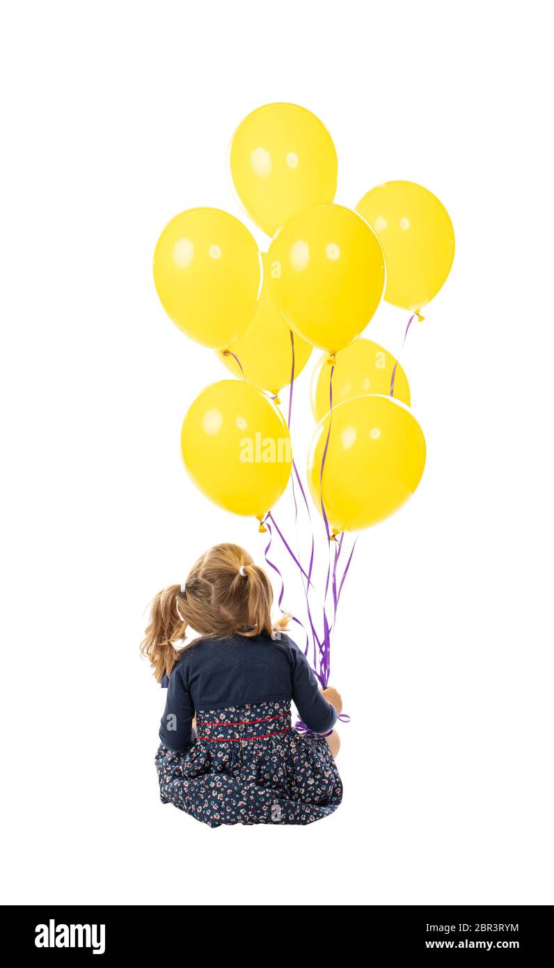 sitting little girl holding yellow balloons in her hand. isolated on ...