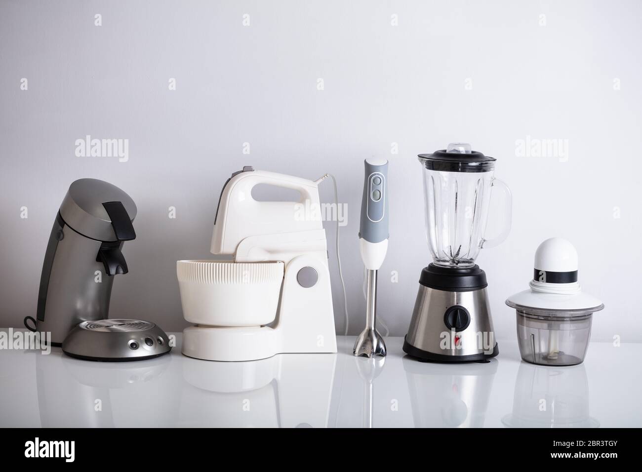 Variety Of Kitchen Appliances In Row Over Reflective Desk Stock Photo ...
