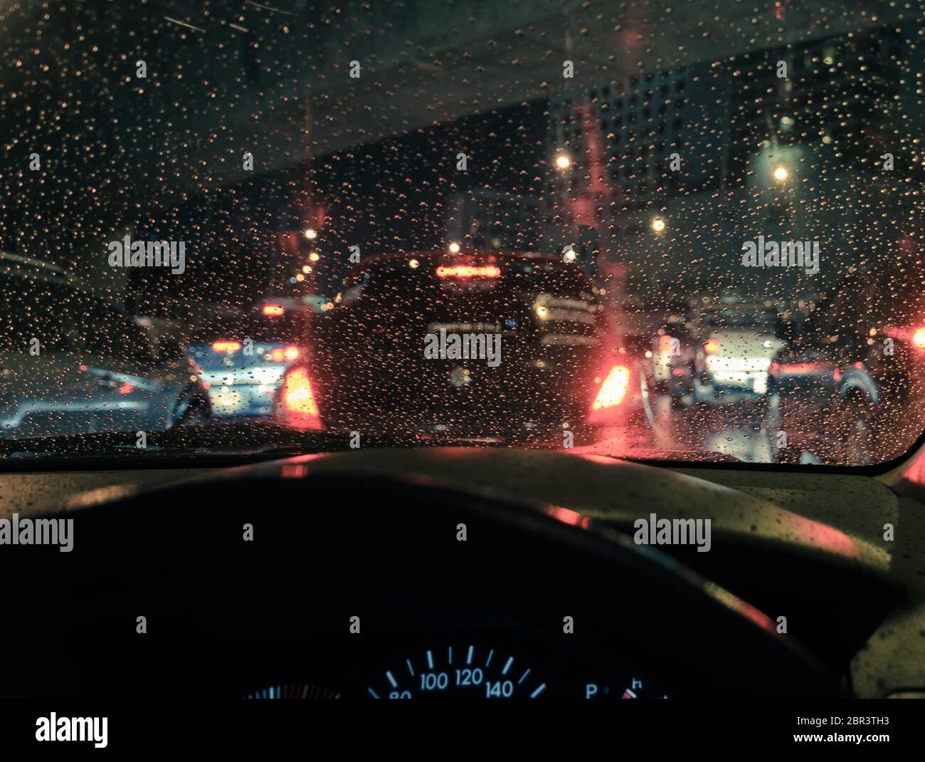 Blurry driving car seen through wet windscreen at night raining. Retro ...