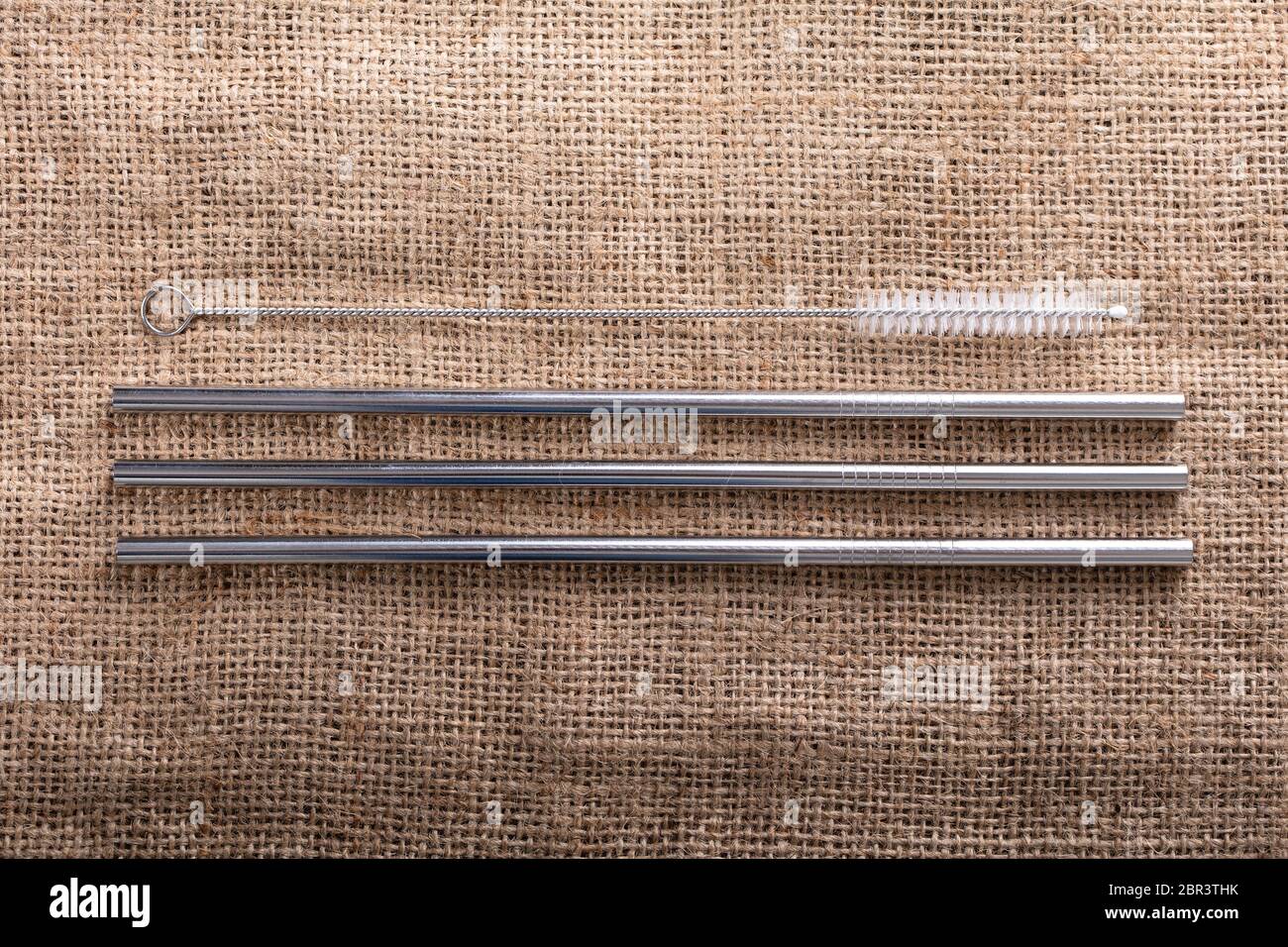 Metallic Straw And Suction Brush On Sack Cloth Stock Photo - Alamy