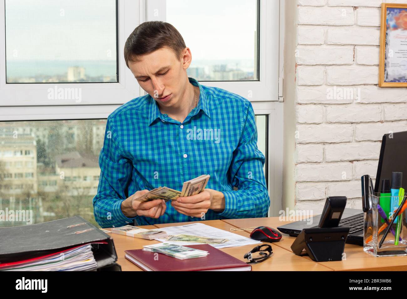 Young office worker counting money Stock Photo - Alamy
