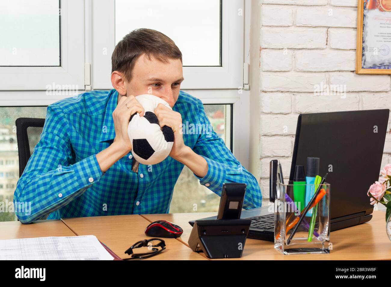 An office worker watches football in the workplace Stock Photo - Alamy