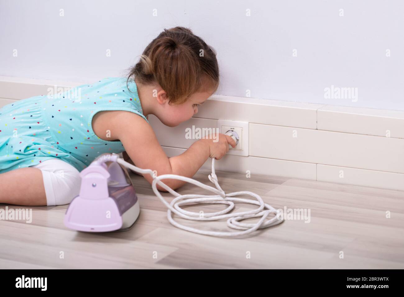 Toddler Trying To Insert Iron Wire In Electric Plug At Home Stock Photo ...