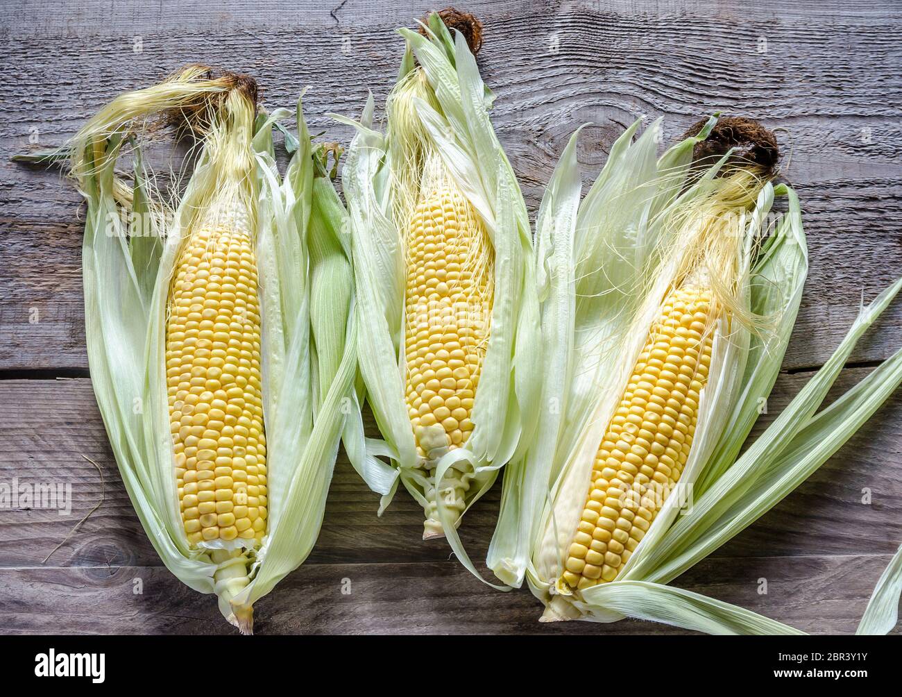 Raw corn on the wooden board Stock Photo - Alamy