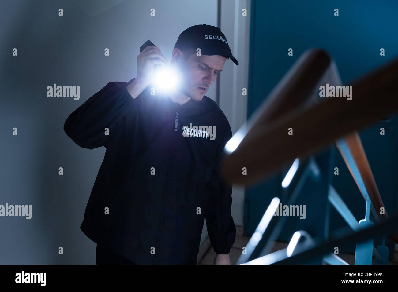 Side View Of Male Security Guard Standing On Staircase Holding ...