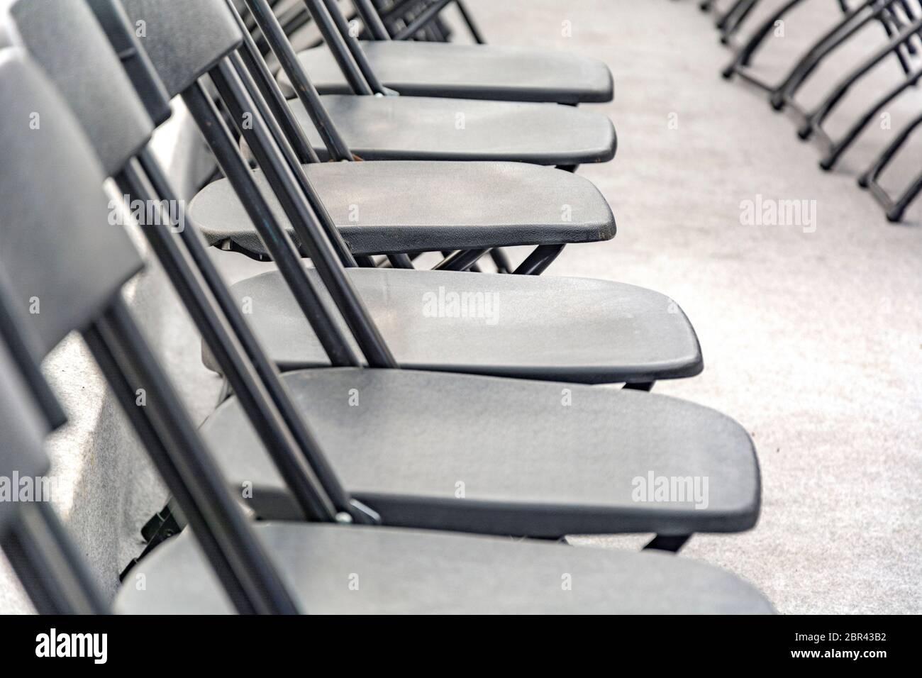 Rows of black folding chairs empty in a conference room Stock Photo - Alamy