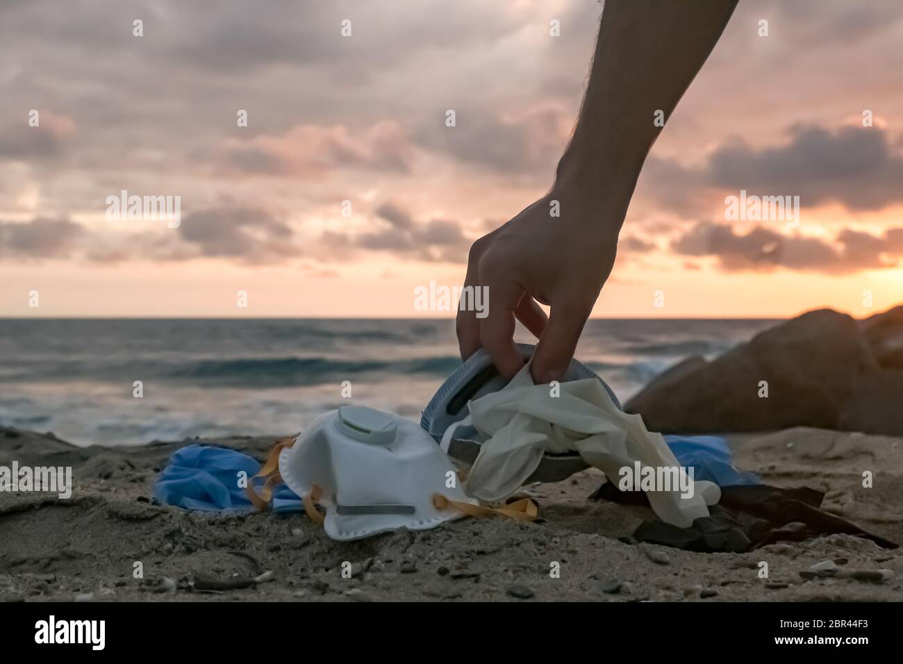 Man hand collect medical waste,mask and plastic gloves garbage trash on ...