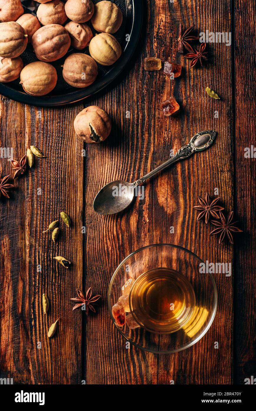 Arabic tea with different spices in armudu glass over wooden surface ...