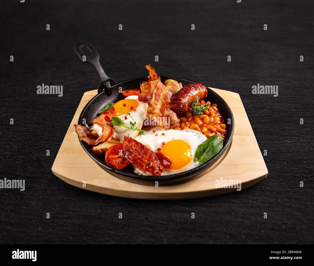 Traditional Full English Breakfast served in cooking pan on black ...