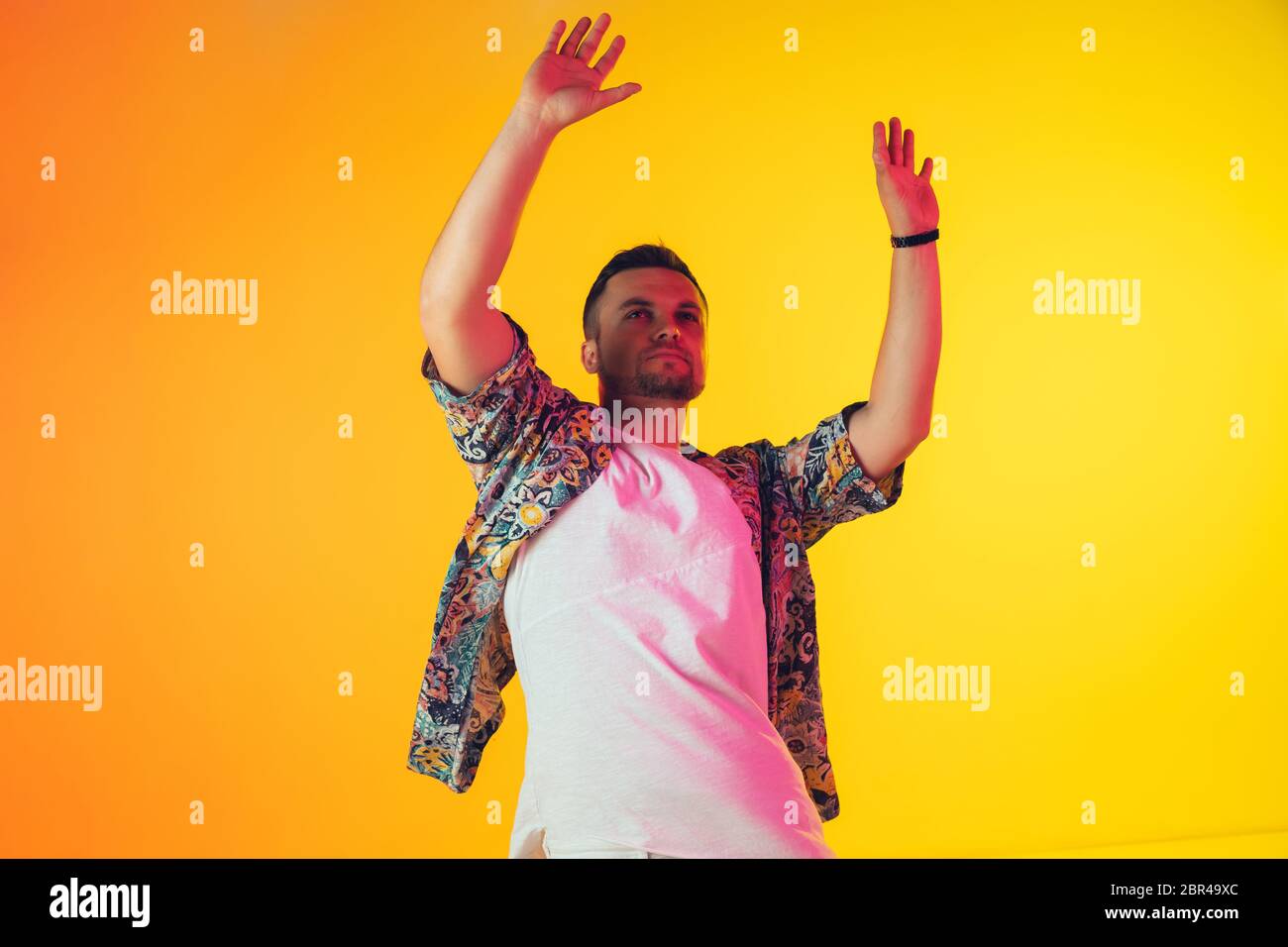 Young caucasian musician in casual dancing on gradient yellow ...